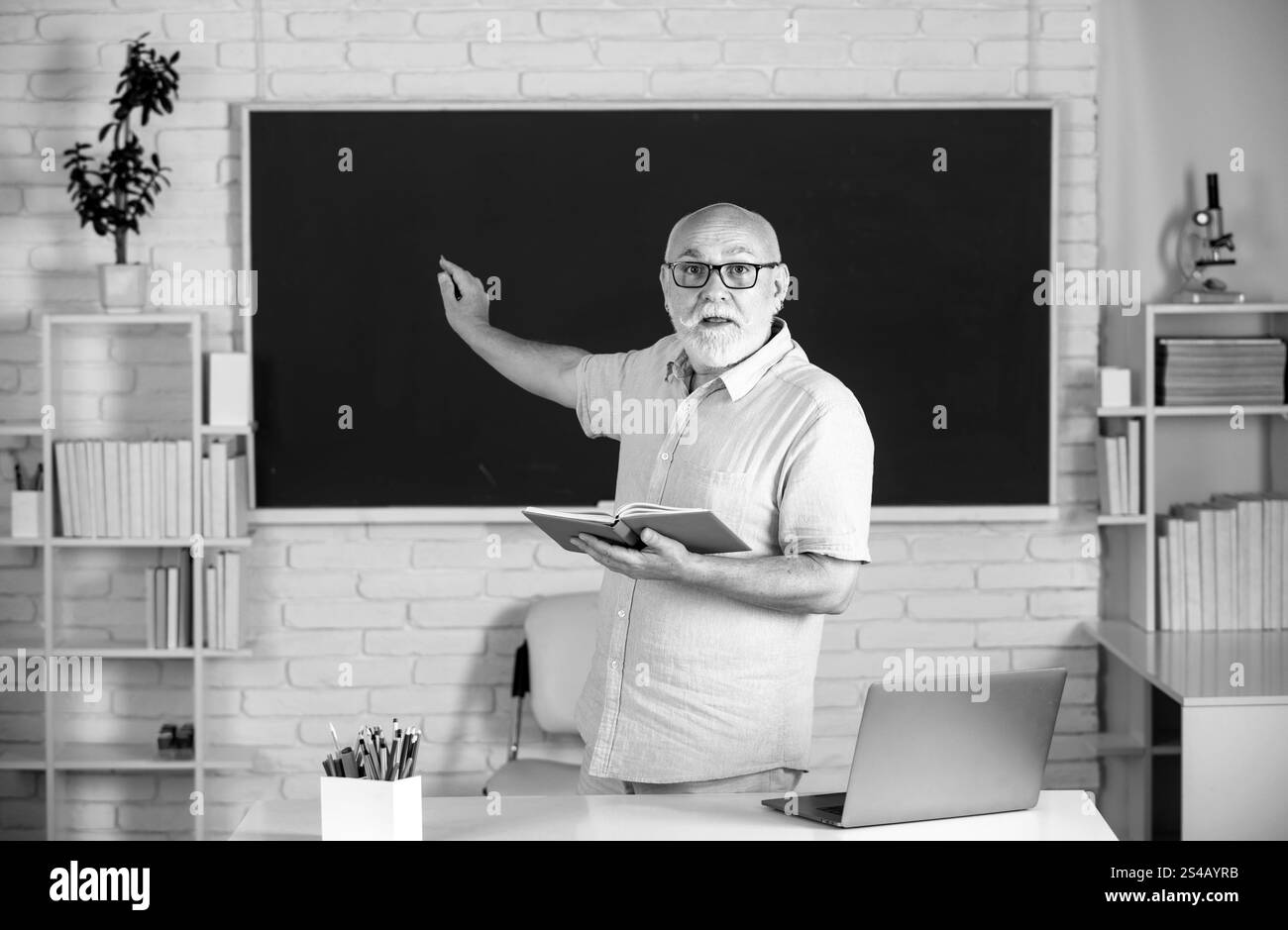 Portrait of senior teacher teaching line of high school students with ...