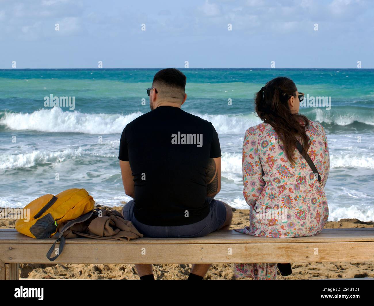 Two Friends Sitting on a Beach Bench Facing the Calm Ocean Waves Stock Photo - Alamy