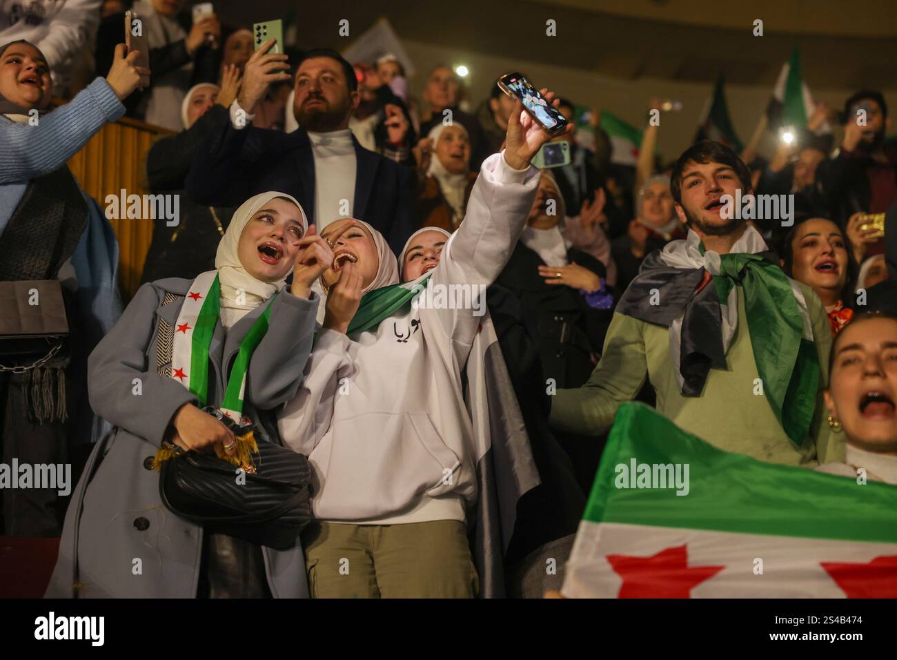 FILE.- Syrians sing and wave post-Assad flags during a concert by the ...