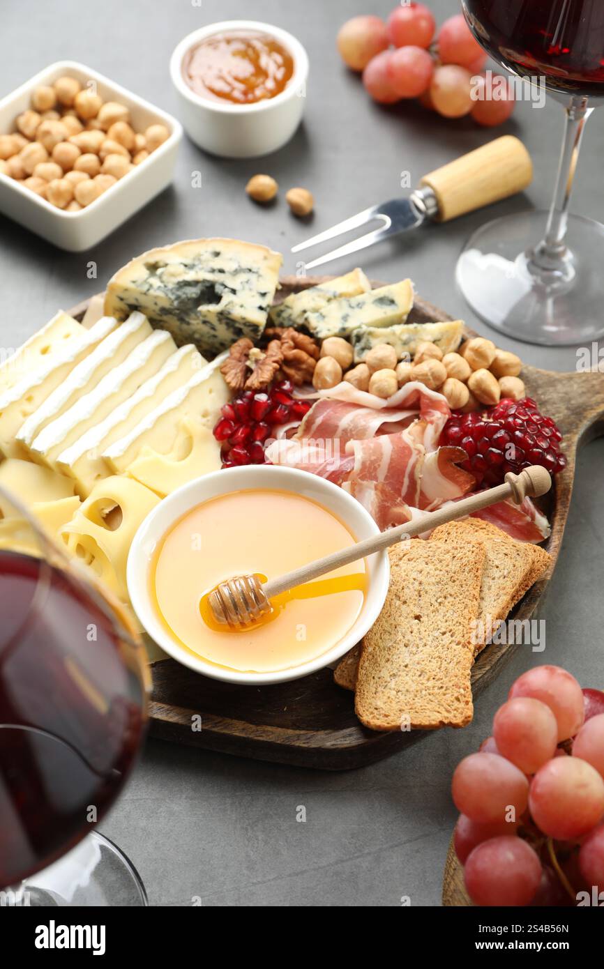 Different types of cut cheese and other snacks on gray textured table ...