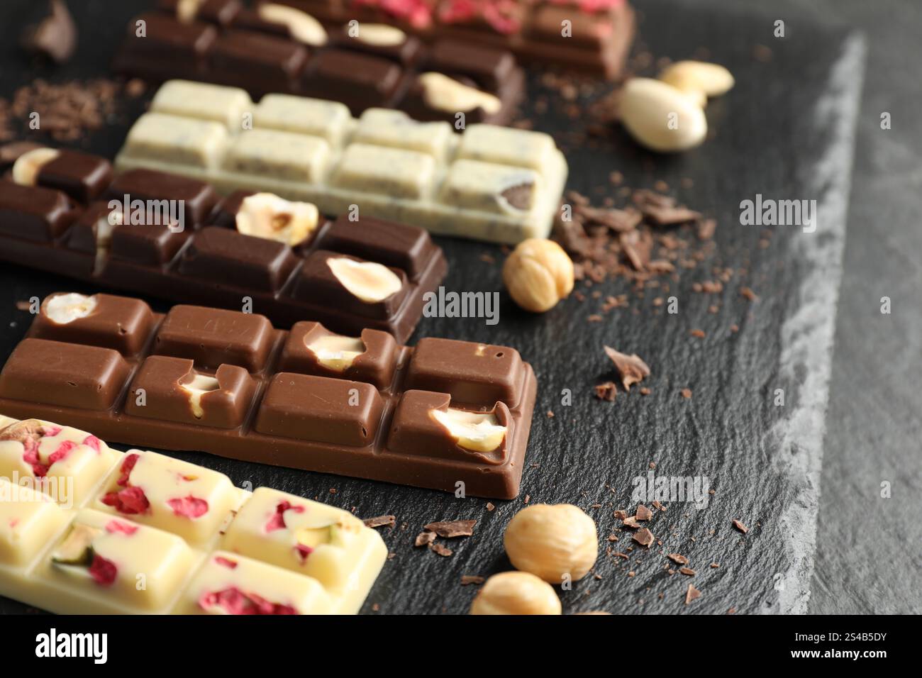 Different tasty chocolate bars with nuts and freeze dried raspberry on ...