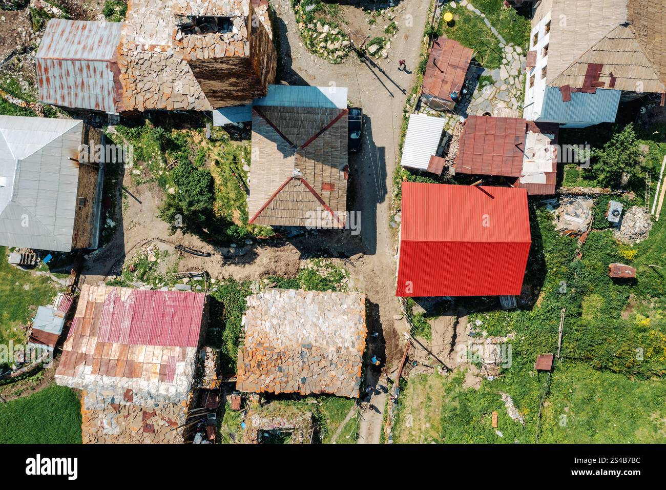 Drone view of rustic rural settlement with stone-roofed houses and ...