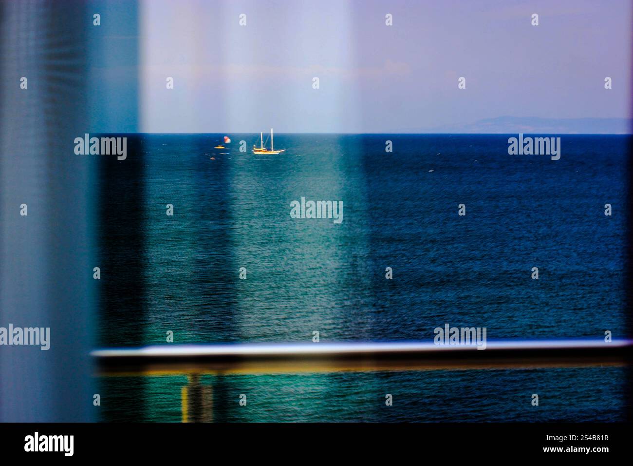 Cinematic conceptual photo of reflection in window of blue sea and ship ...
