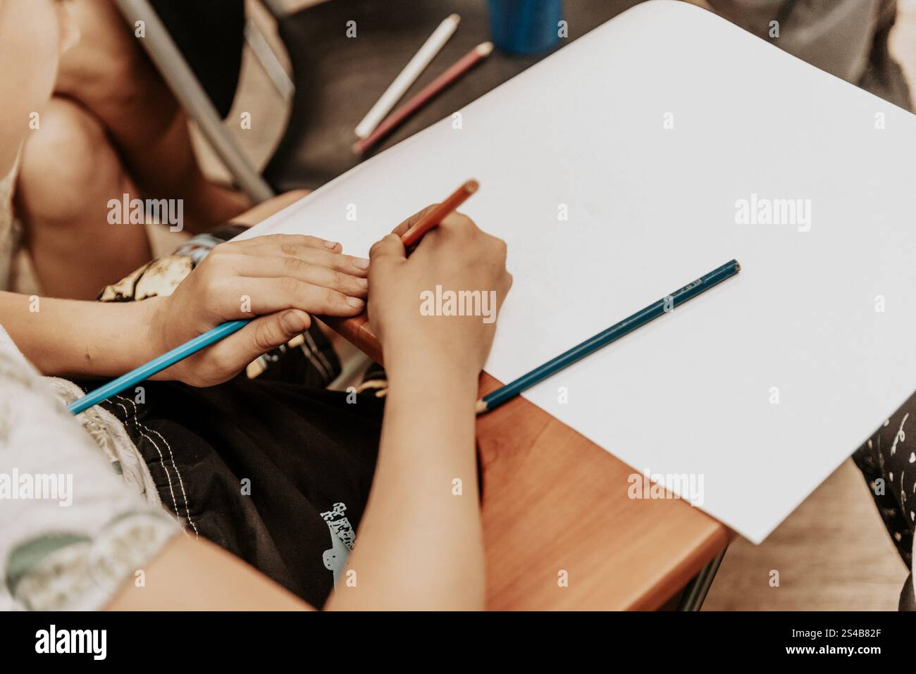 Child drawing with colored pencil on paper, kid draw in kindergarten ...