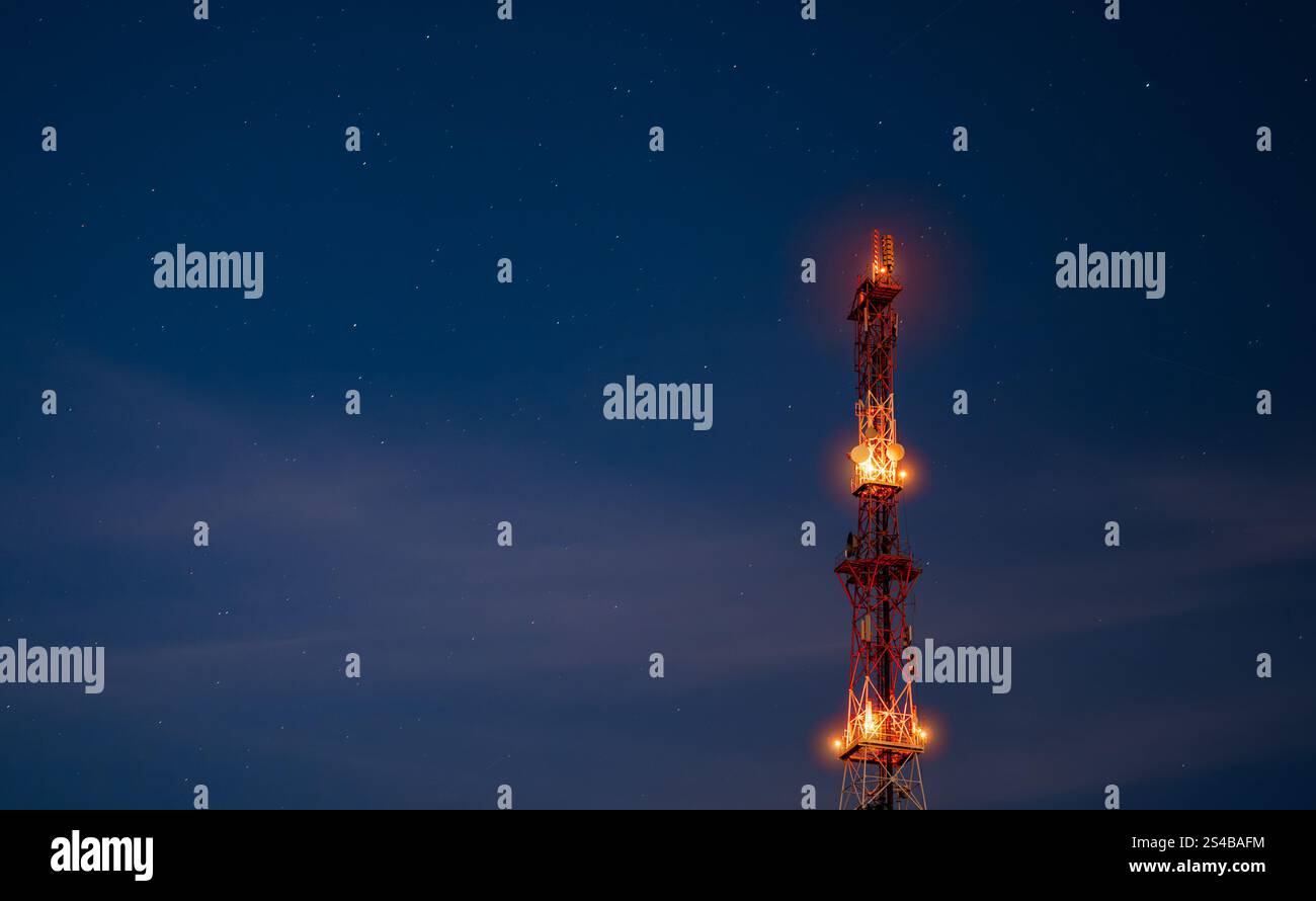 A towering communication structure stands tall against the night sky ...