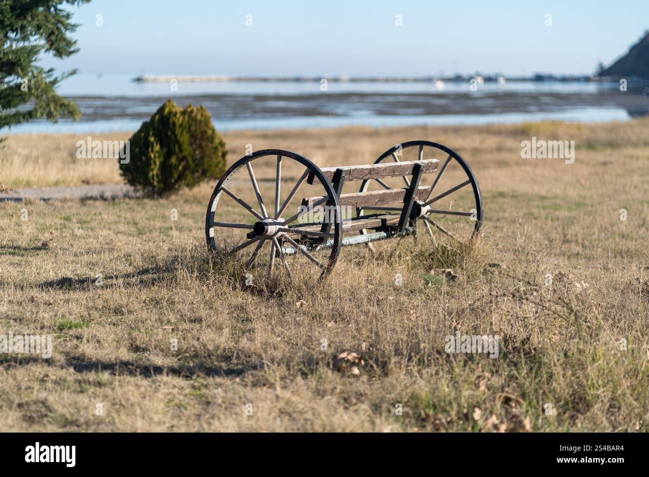 Rustic Wagon Wheel Bench on Beach Stock Photo - Alamy
