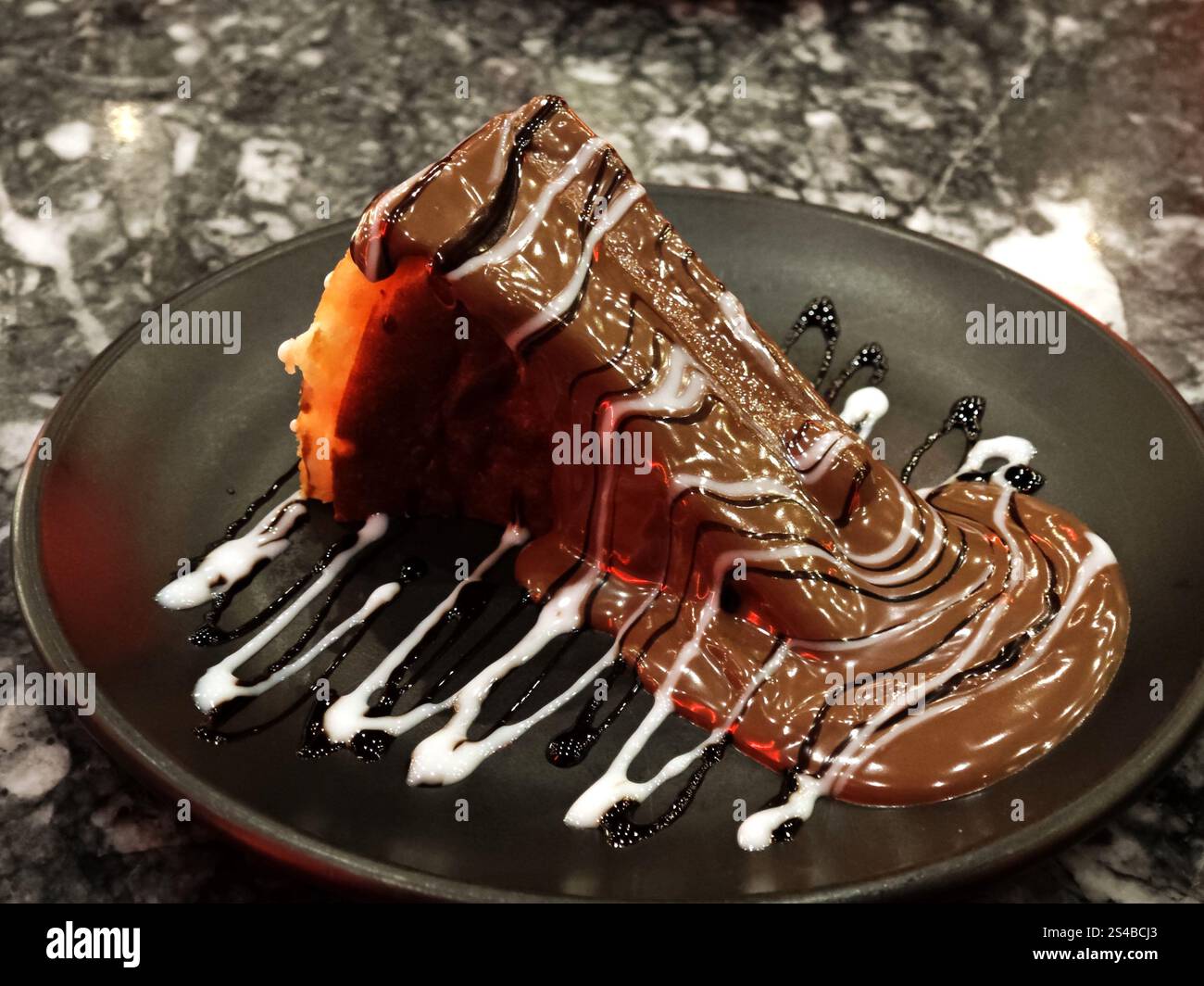 A plate of Basque burnt cheesecake dessert topped with melted chocolate ...