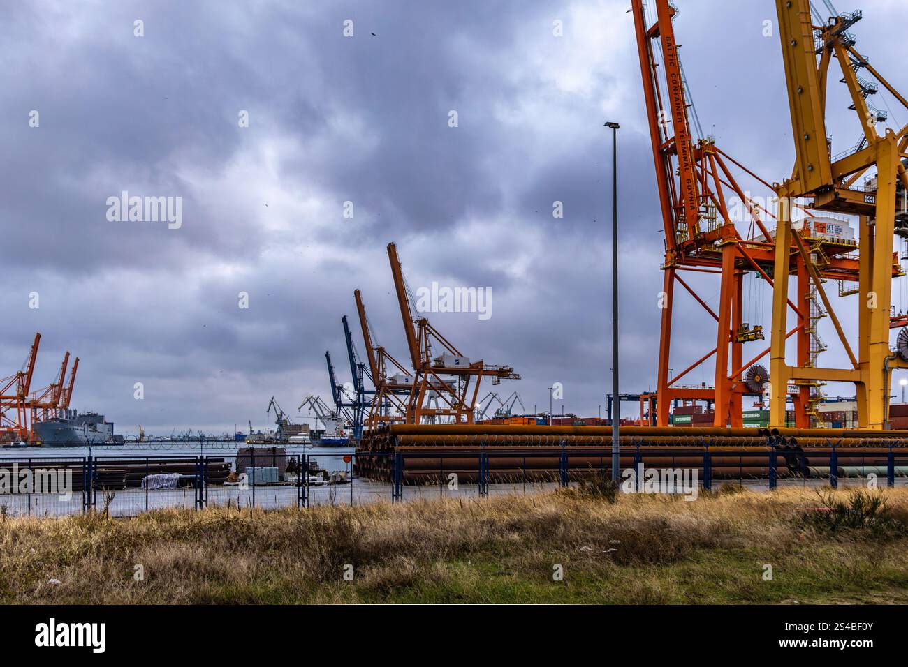 Tall cranes in the port, unloading goods from containers from ships, cargo port in Gdynia Stock ...