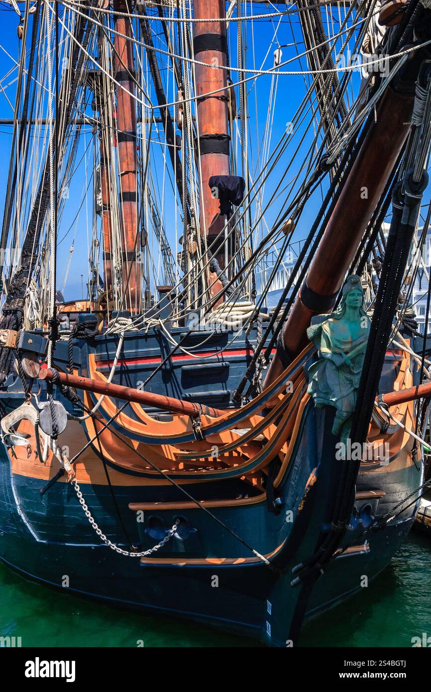 A large ship with a statue of a woman on the front. The ship is docked ...