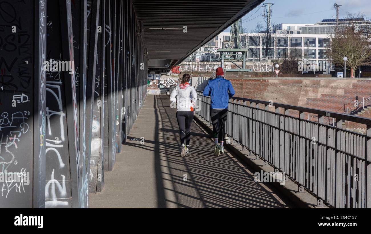Hamburg, Germany. 08th Jan, 2025. A couple jogs across the Oberhafen ...