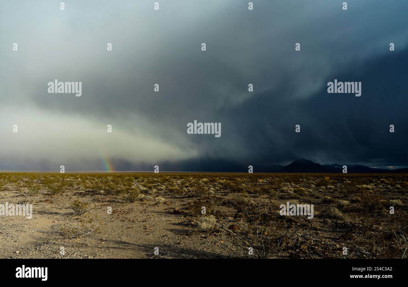 A rare winter storm in Death Valley with a faint rainbow cutting ...