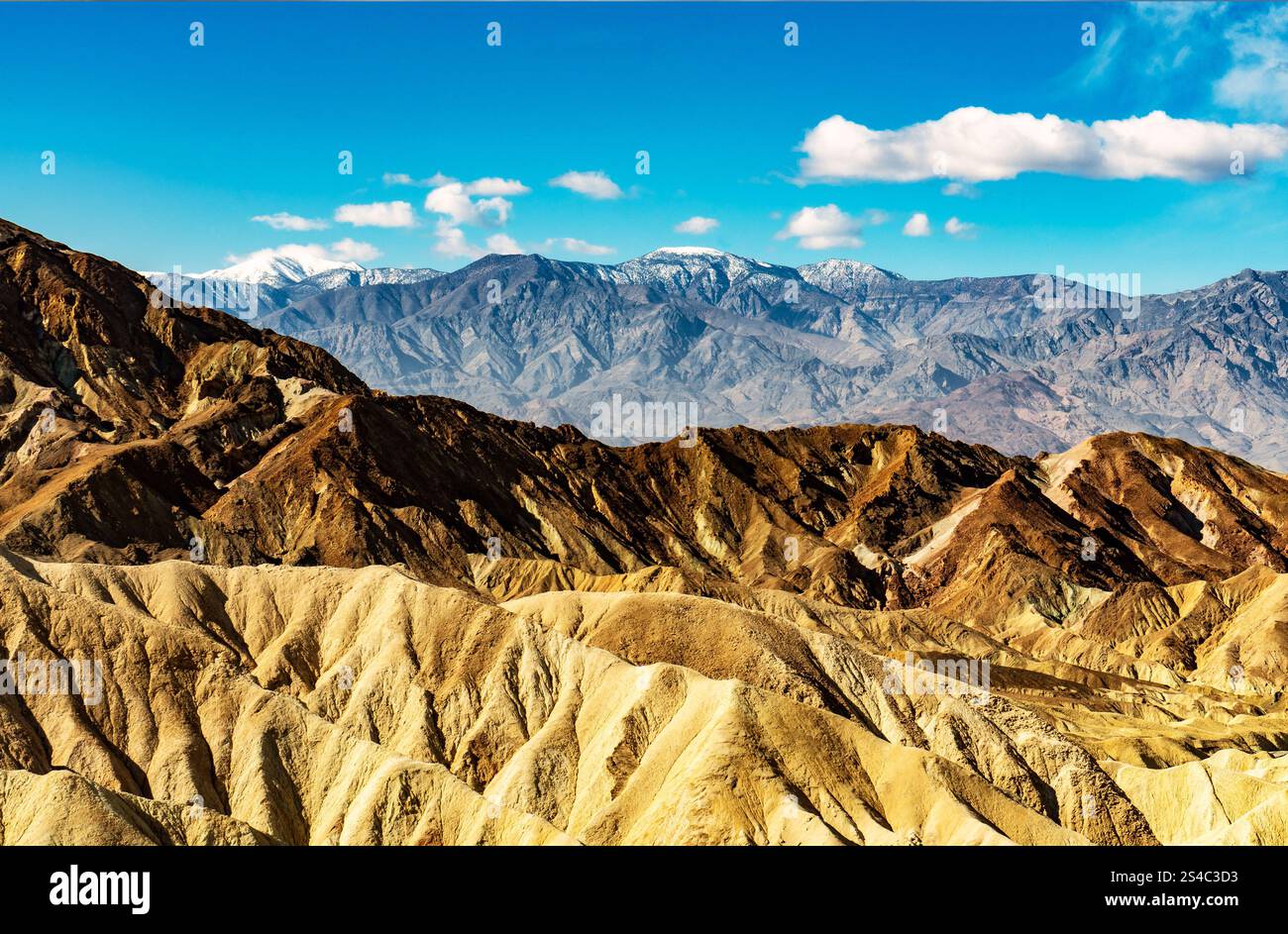 Vibrant view of Death Valley's rugged badlands with snow-capped peaks ...
