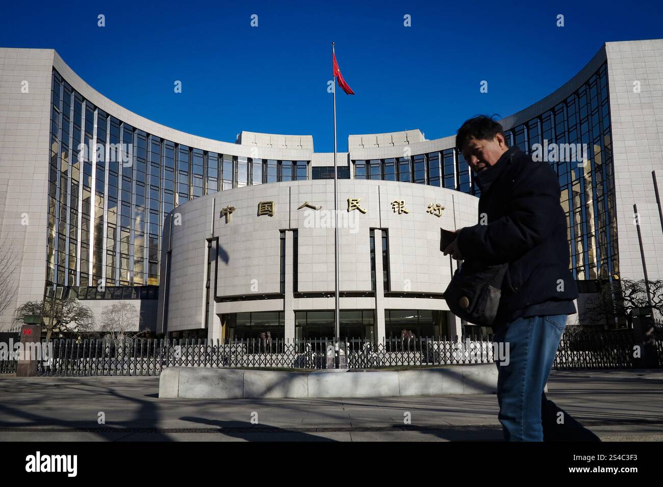 Pedestrian walks past the office building of the People's Bank of China ...