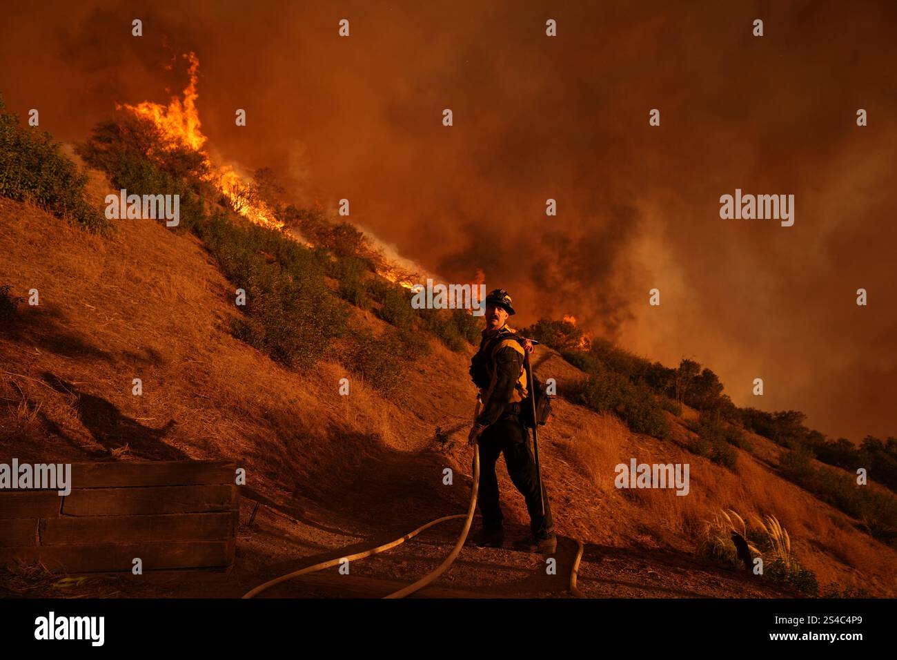 A firefighter battles the Palisades Fire in Mandeville Canyon Saturday ...
