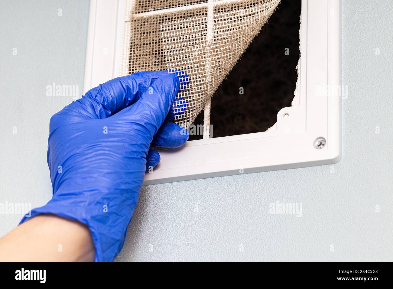 man cleaning dirty ventilation grille in house Stock Photo - Alamy