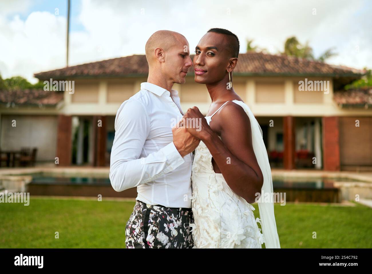 LGBTQ wedding at tropical villa. Ambiguous gender fluid bride in white ...