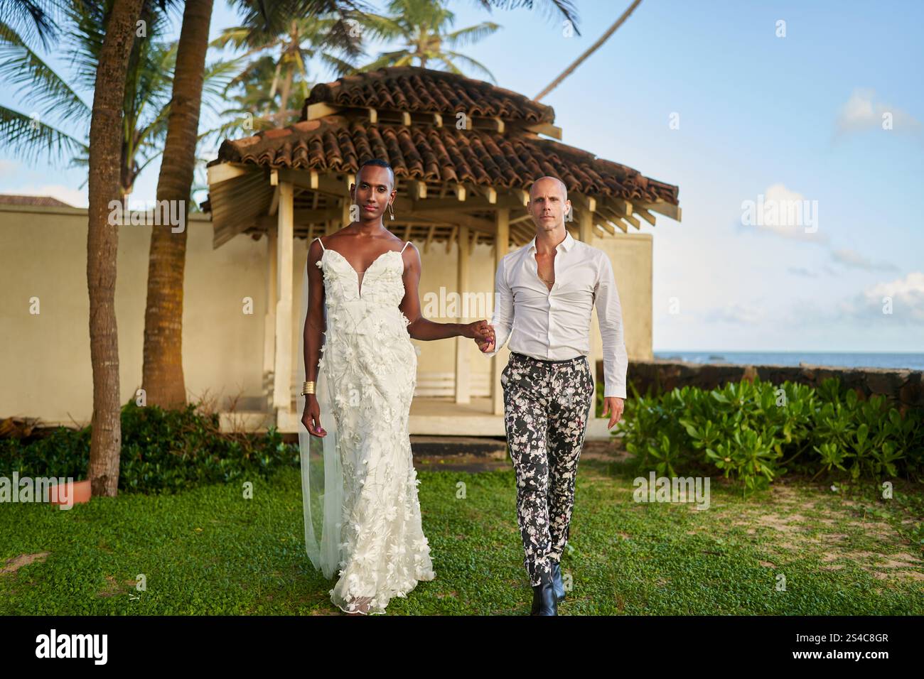 Ambiguous gender fluid person in white bridal dress holds hands with ...