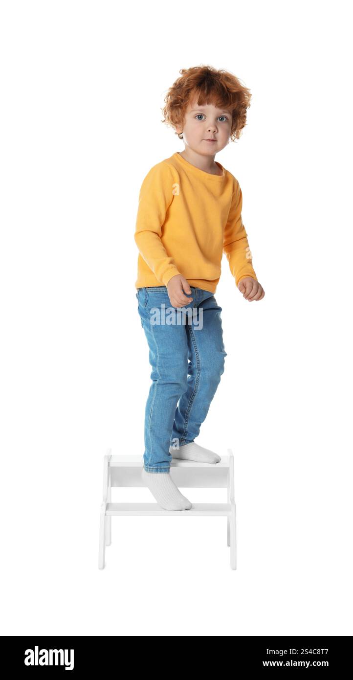 Little boy standing on step stool against white background Stock Photo ...