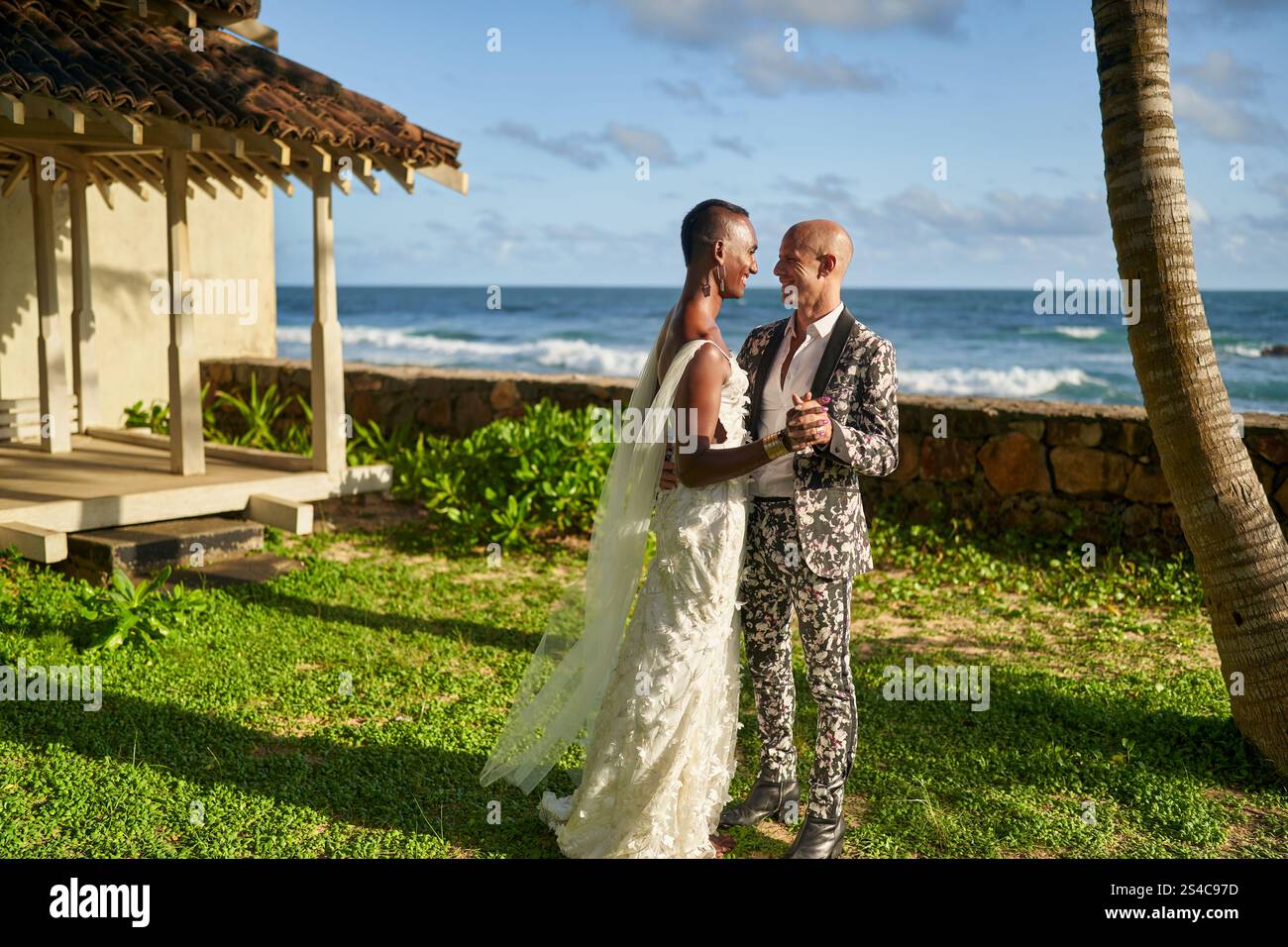 LGBTQ couple in wedding clothes by tropical villa. Ambiguous gender ...