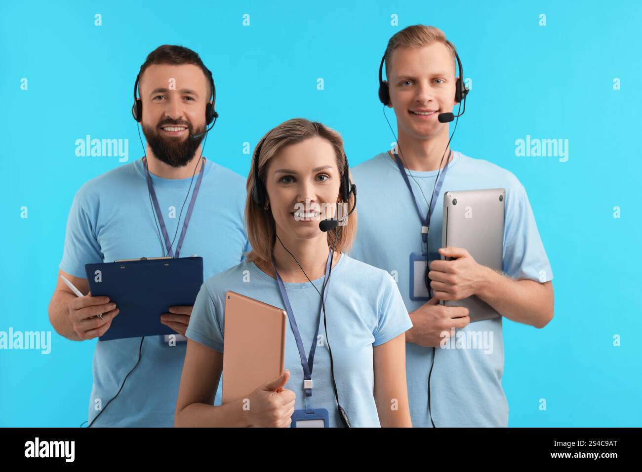 Technical support call center. Team of friendly operators on light blue ...