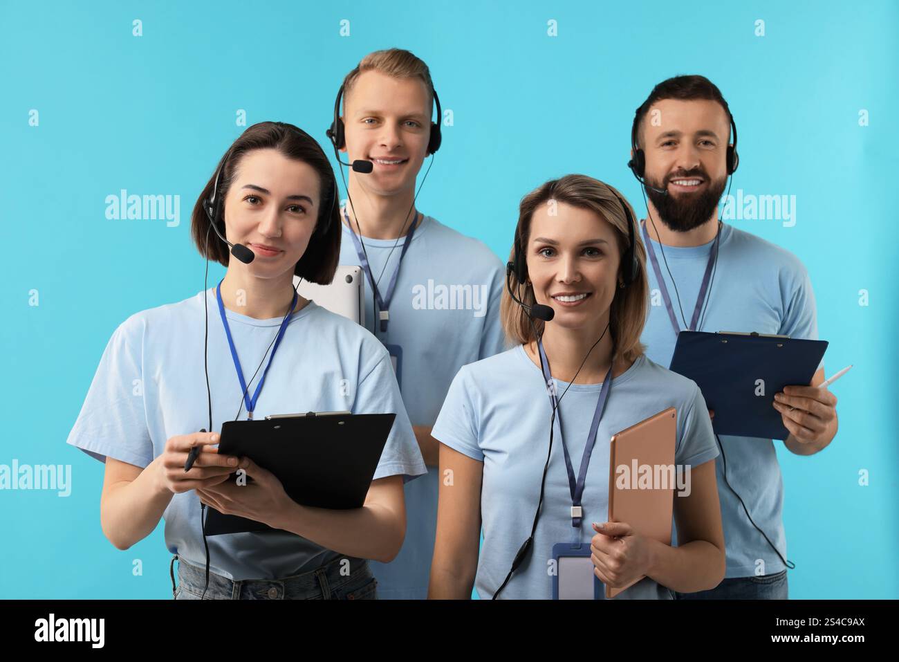 Technical support call center. Team of friendly operators on light blue ...