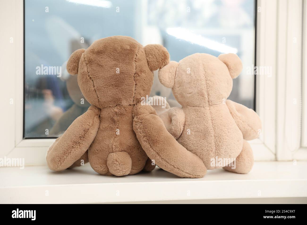Teddy bears on window sill at home, back view Stock Photo - Alamy