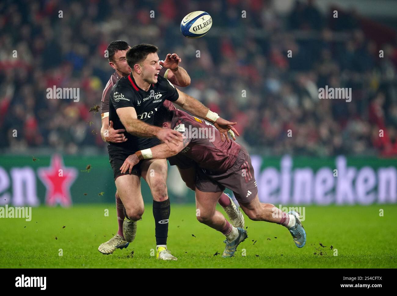 Saracens' Fergus Burke is tackled by Munster's Tom Farrell (left) and ...