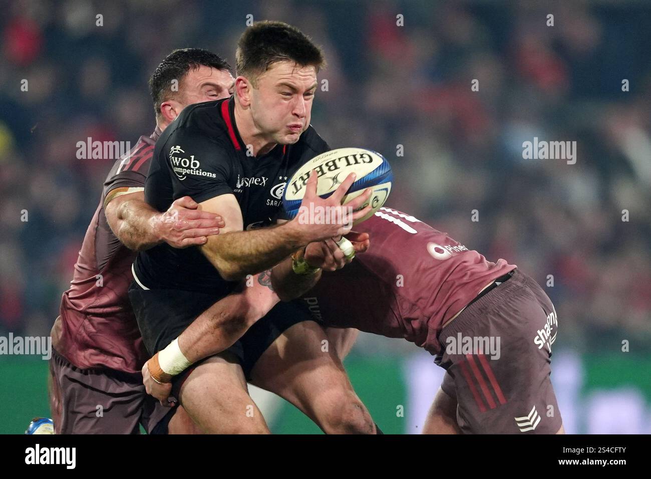 Saracens' Fergus Burke is tackled by Munster's Tom Farrell (left) and ...