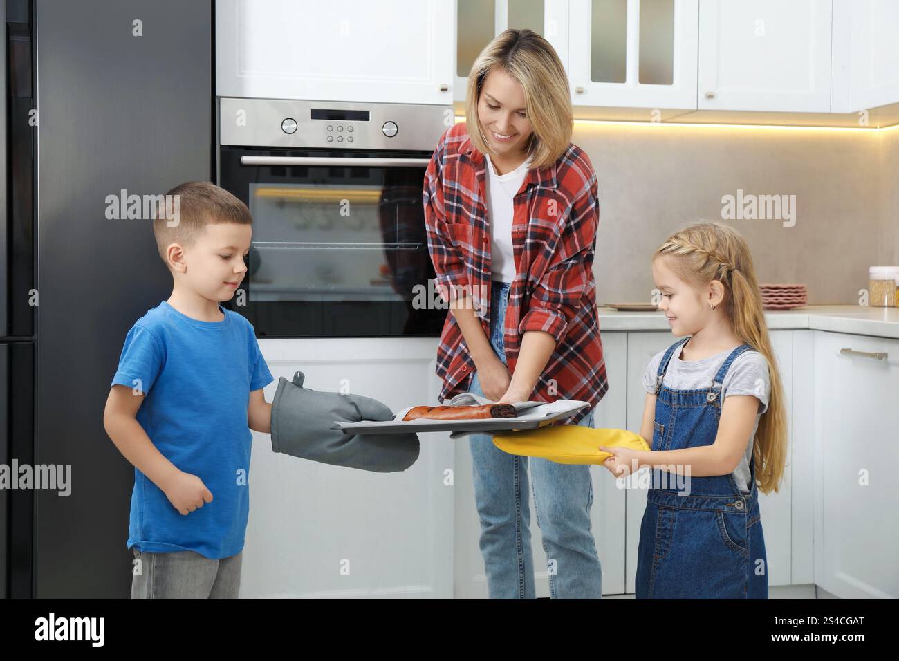 Little helpers. Children baking with their mother at home Stock Photo ...