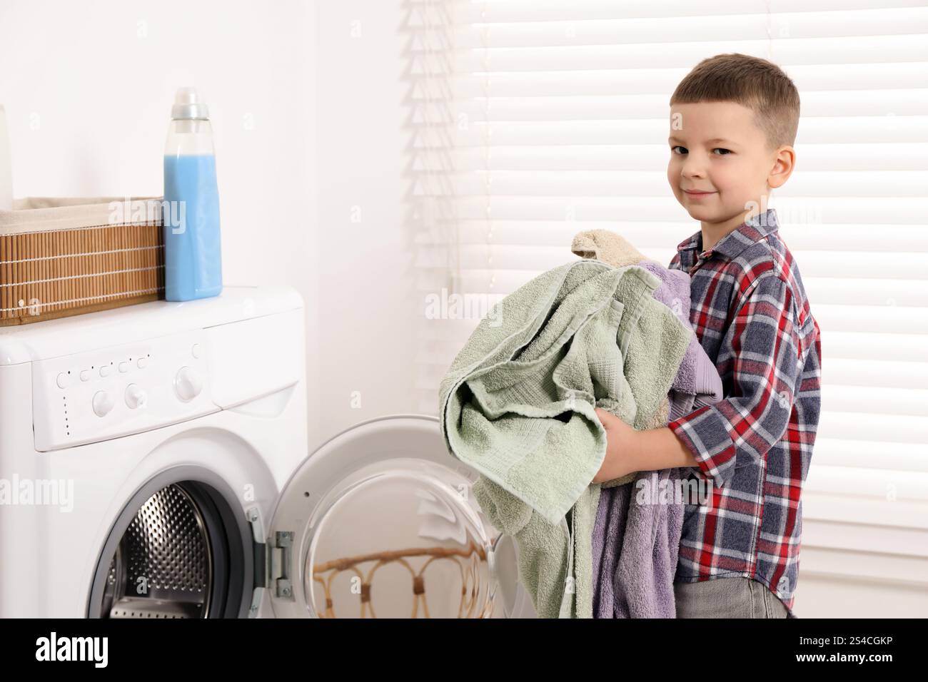 Little helper. Cute boy doing laundry at home Stock Photo - Alamy