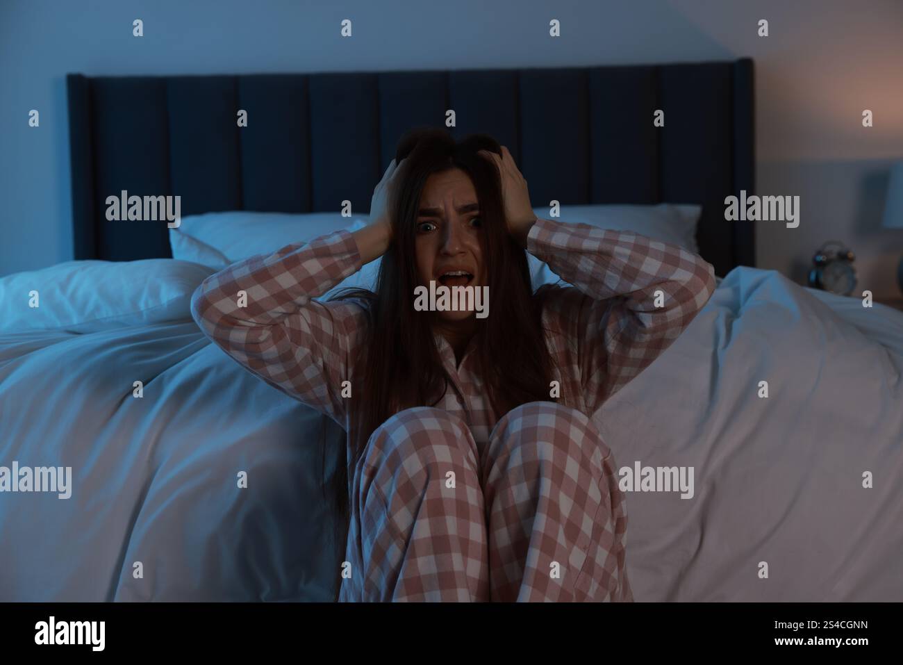 Fear of darkness. Scared young woman in bedroom at night Stock Photo ...