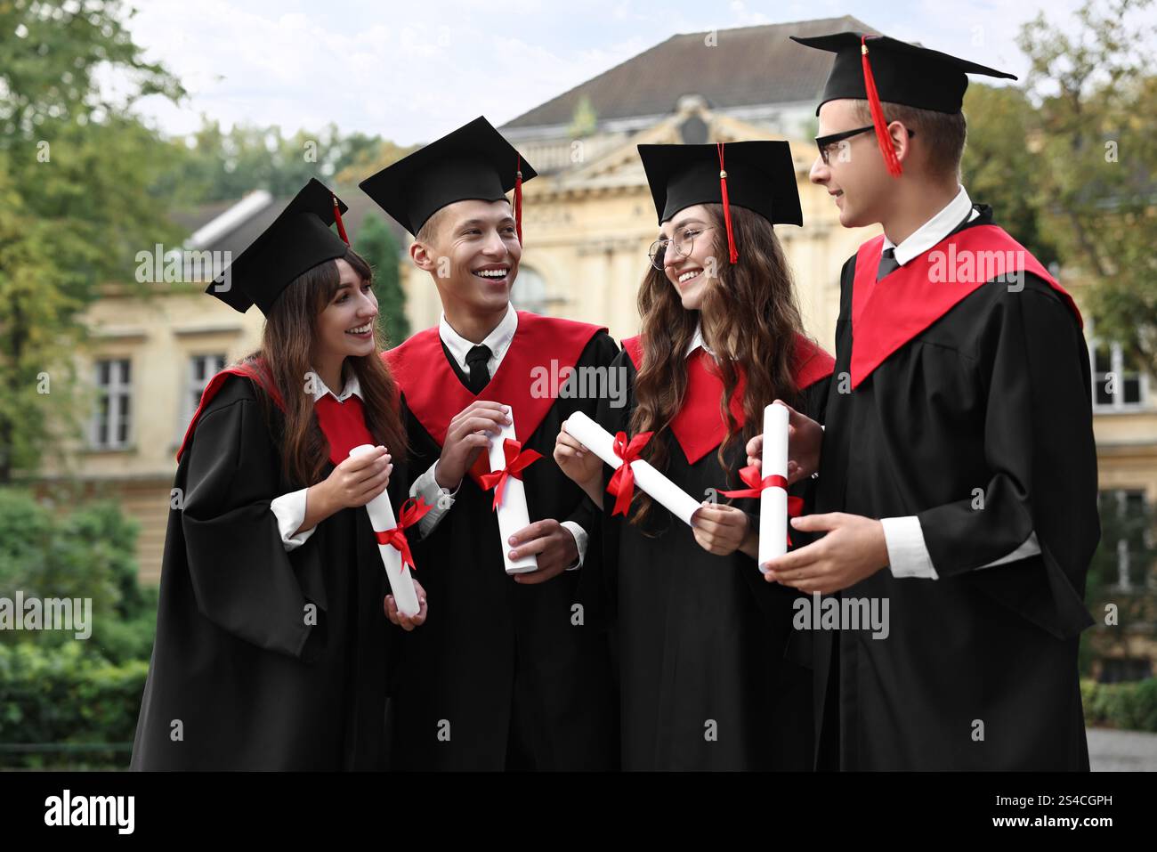 Happy students with diplomas after graduation ceremony outdoors Stock ...
