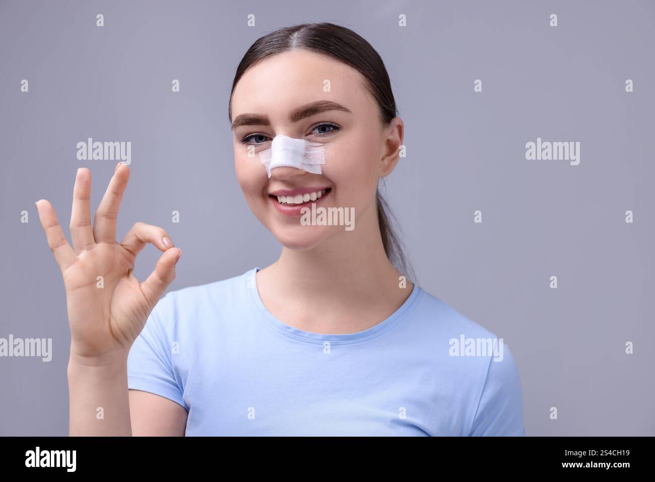 Woman with medical bandage on her nose after plastic surgery operation ...