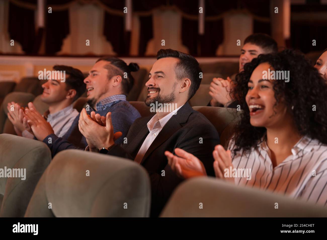 Group of exited people applauding in theatre Stock Photo - Alamy