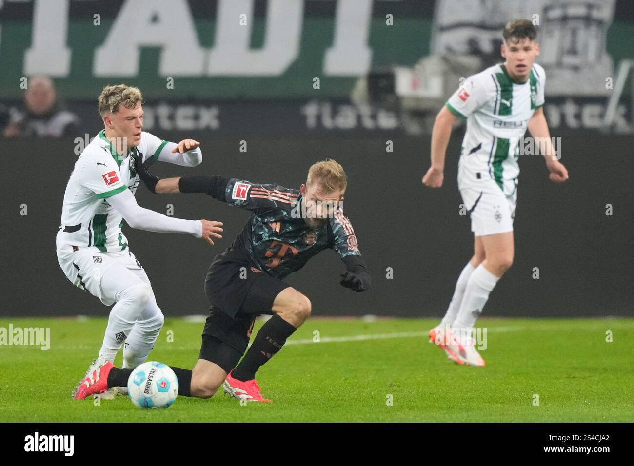 Bayern's Konrad Laimer, center, duels for the ball with ...