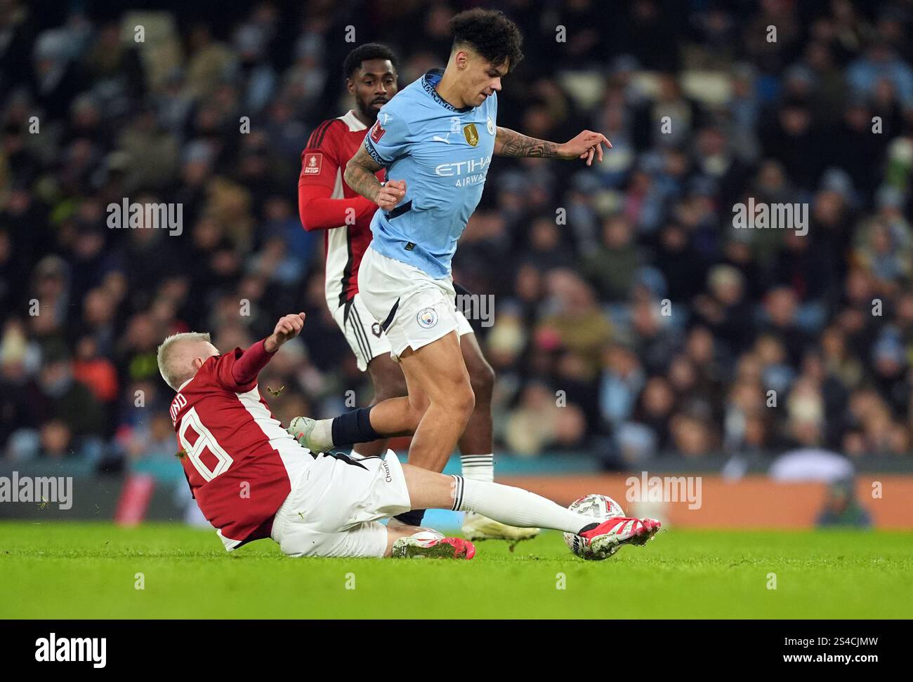 Manchester City's Nico O'Reilly and Salford City's Matthew Lund battle for the ball during the ...