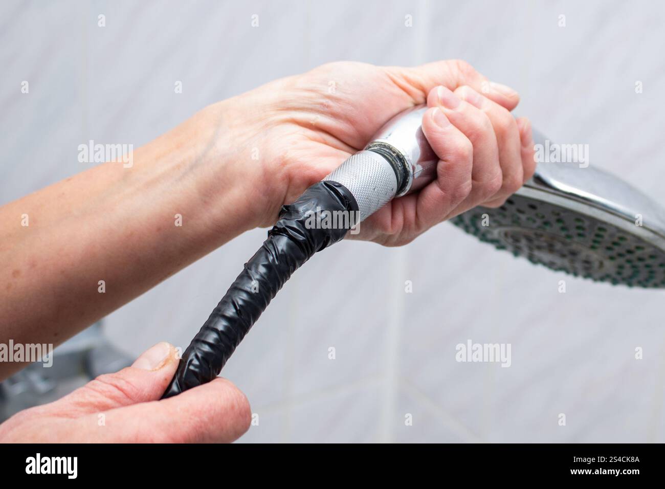 Woman changing broken shower hose in bathroom. Female plumber hands ...