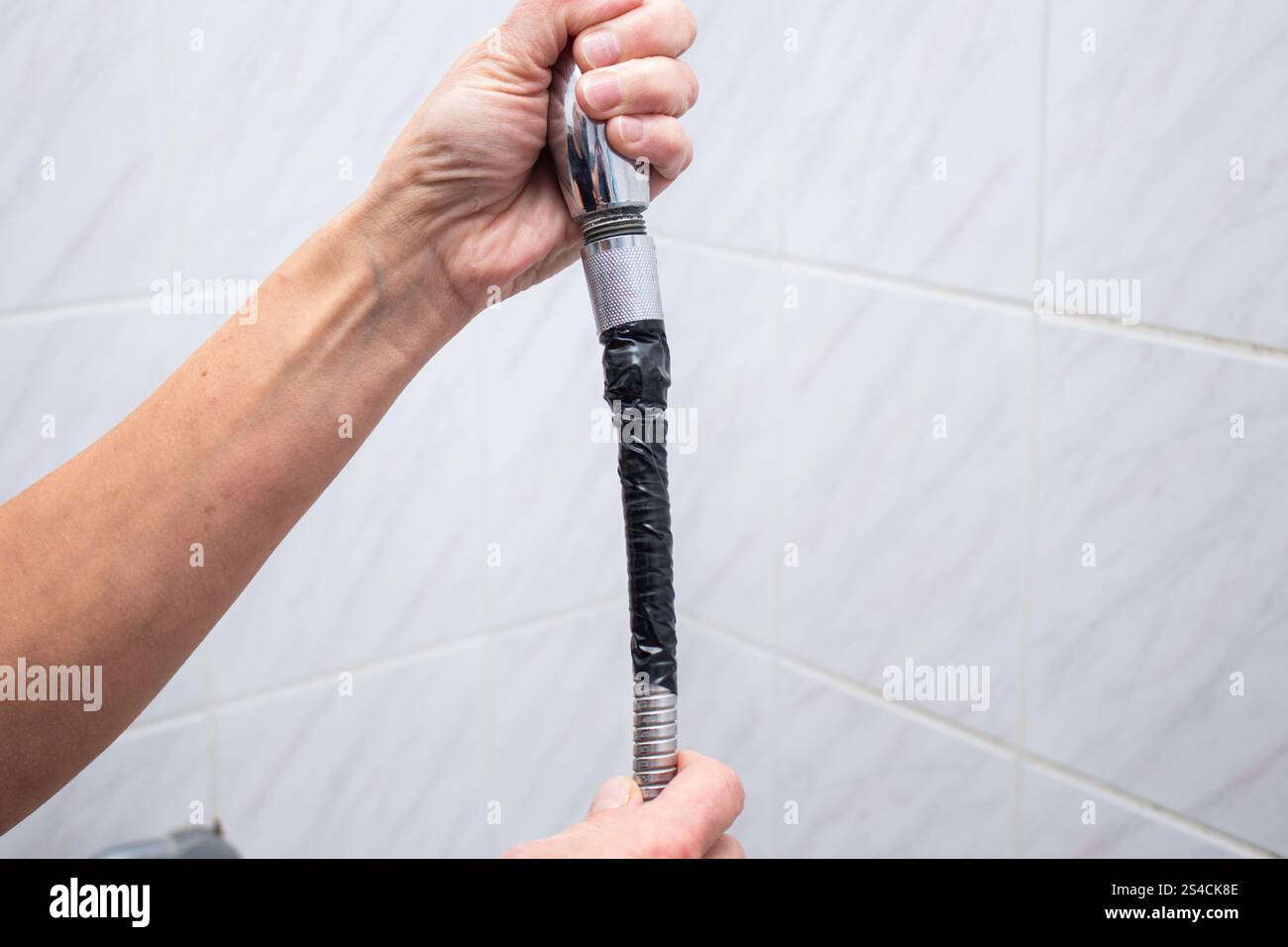 Woman changing broken shower hose in bathroom. Female plumber hands ...