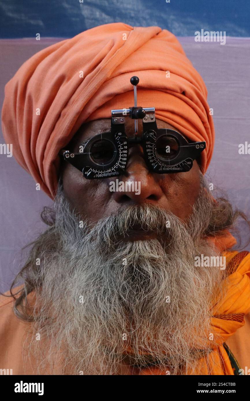 Kolkata, India. 11th Jan, 2025. A doctor examines the eye of a Sadhu or ...