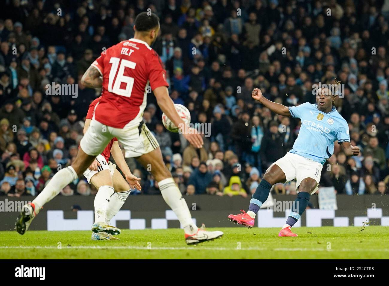 Manchester City's Jeremy Doku, right, scores on a penalty kick during ...