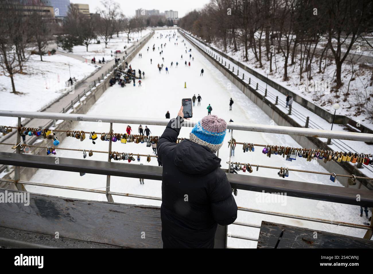 Ottawa, Can. 11th Jan, 2025. A person records video of skaters on the ...