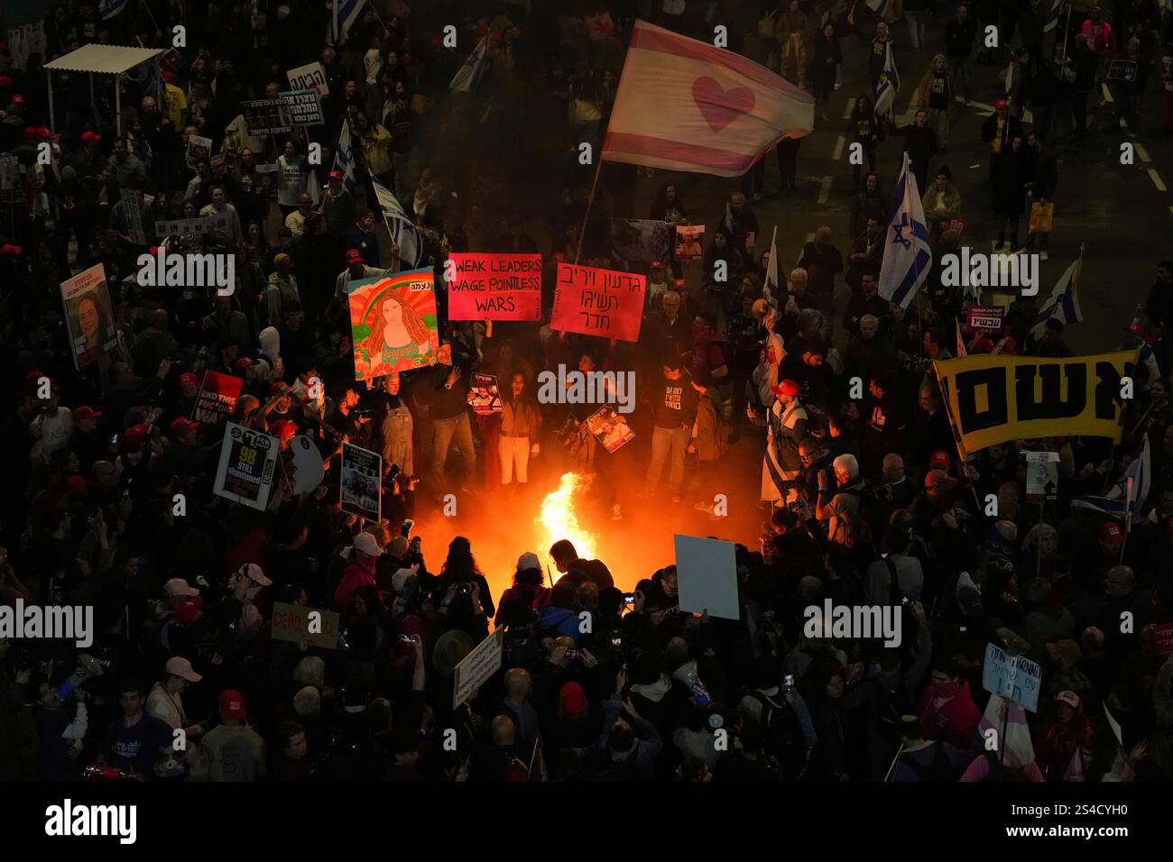 Demonstrators light a bonfire during a protest demanding a cease-fire ...