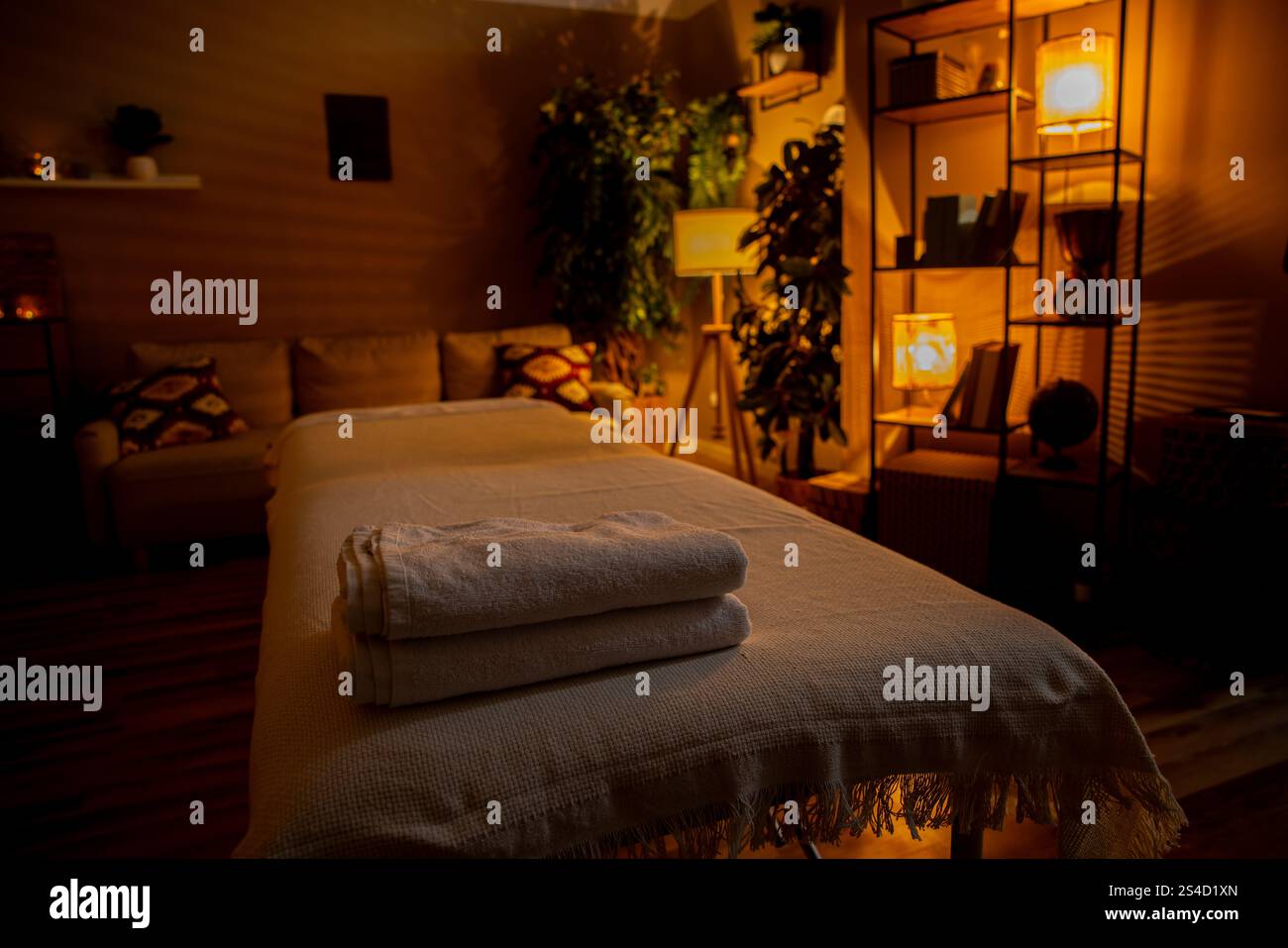 The tranquil spa setting features a cozy massage table, inviting ...