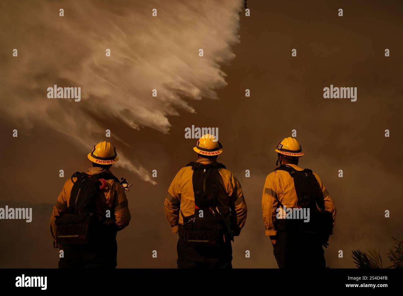 Firefighters watch water drops on the Palisades Fire in Mandeville ...