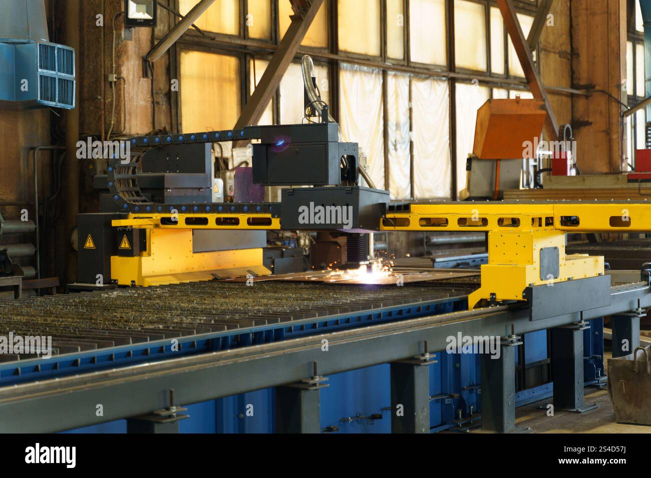 A large industrial machine expertly conducts laser cutting on metal ...