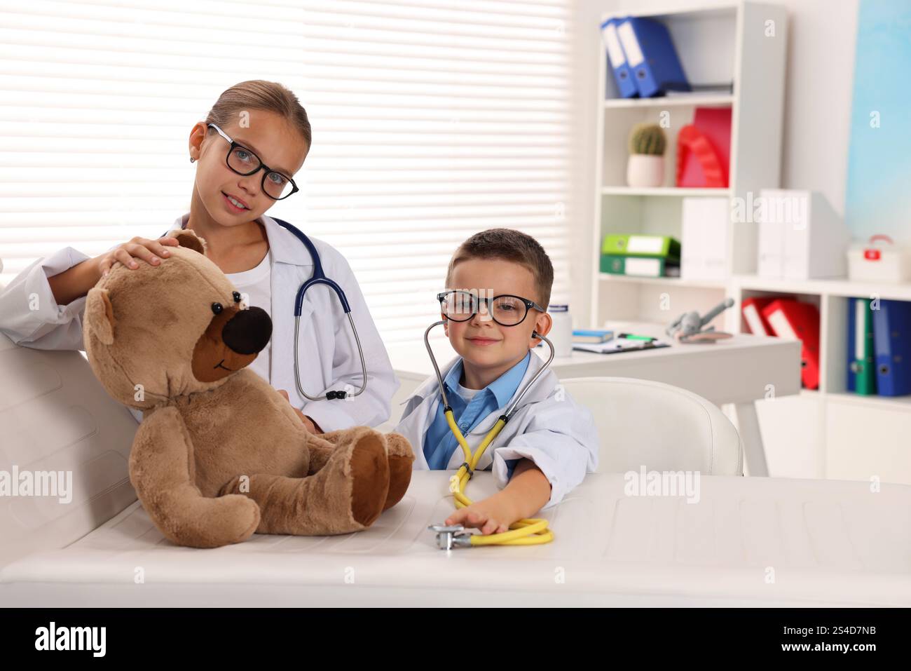 Little boy and girl with toy pretending to be doctors indoors Stock ...