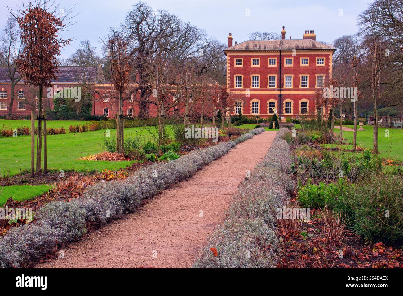 A pathway in the wintered gardens of Lytham Hall, with the historic ...