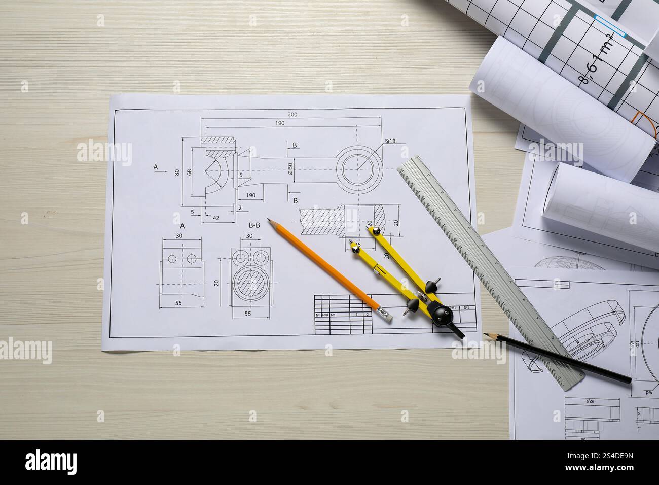 Different engineering drawings, pencils, ruler and divider on wooden ...