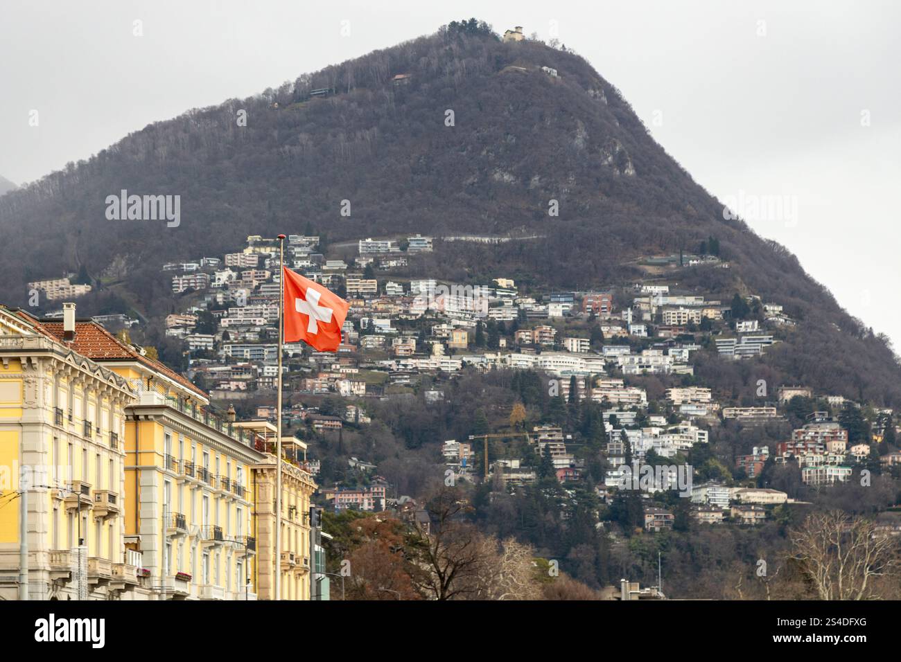 Swiss flag waving, with the city of Lugano and Monte Bre forming the ...