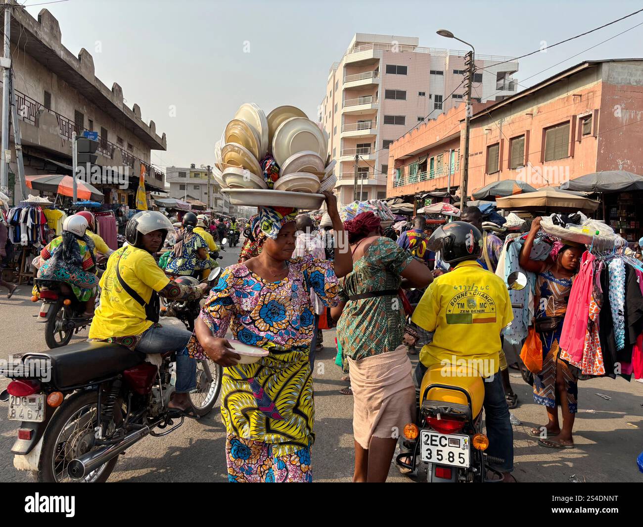 A plate vendor makes her way to the market in Cotonou, Benin, Saturday ...